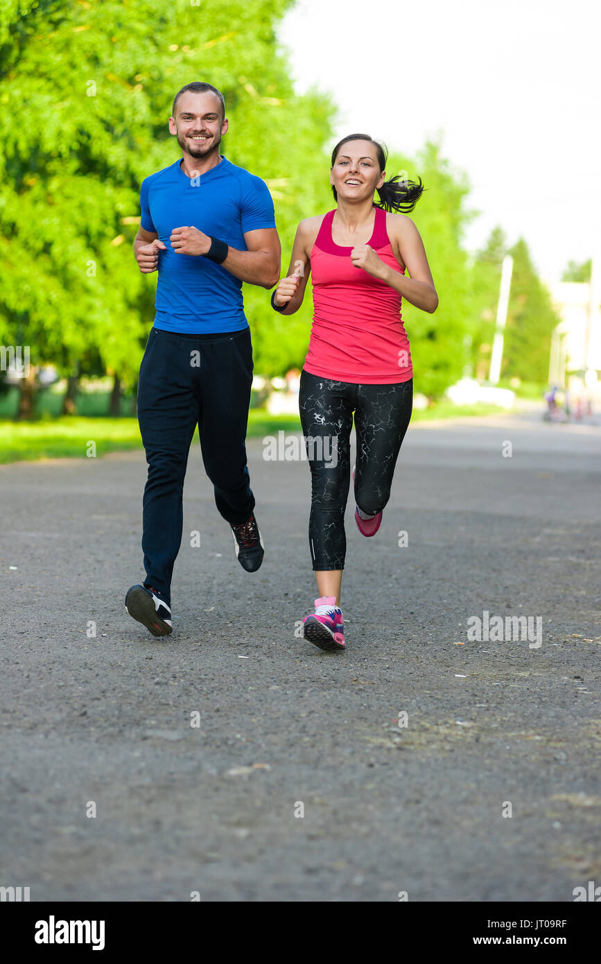 Runners training outdoors working out. City running couple jogging ...