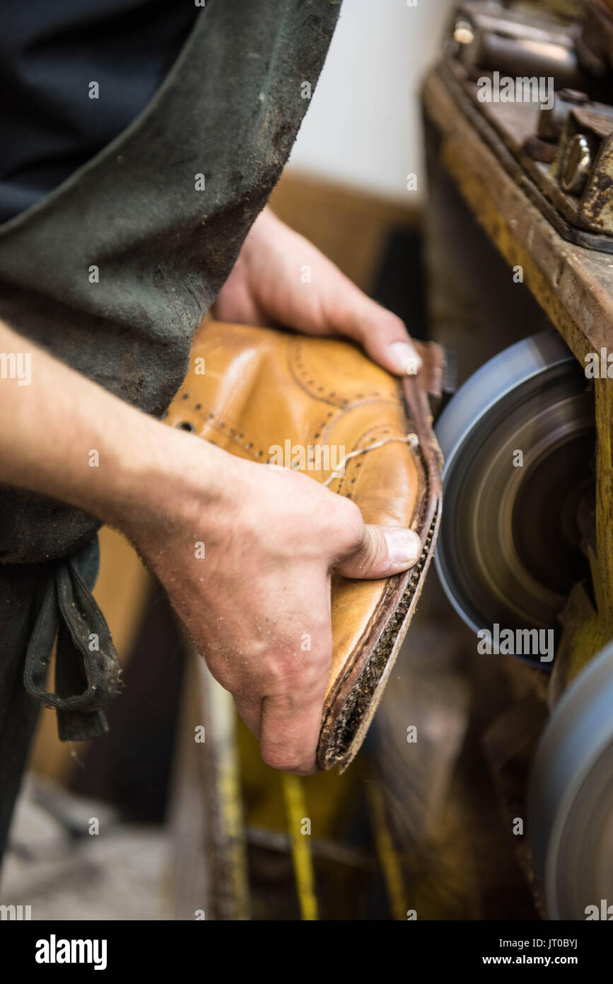 Cobbler repairing leather shoes inside a traditional workshop. Tools ...