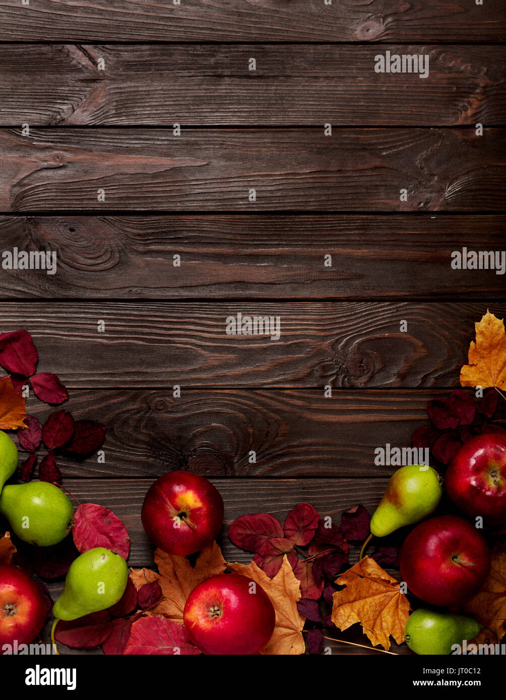 Flat lay frame of autumn crimson and yellow leaves, pears and apples on ...
