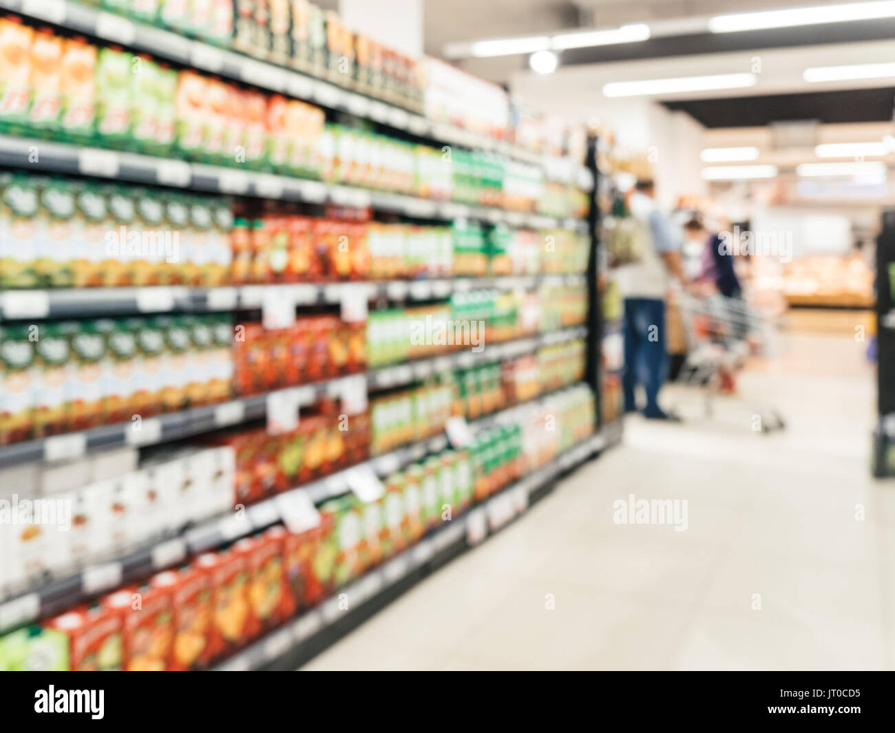 Abstract blurred supermarket aisle with colorful shelves and ...