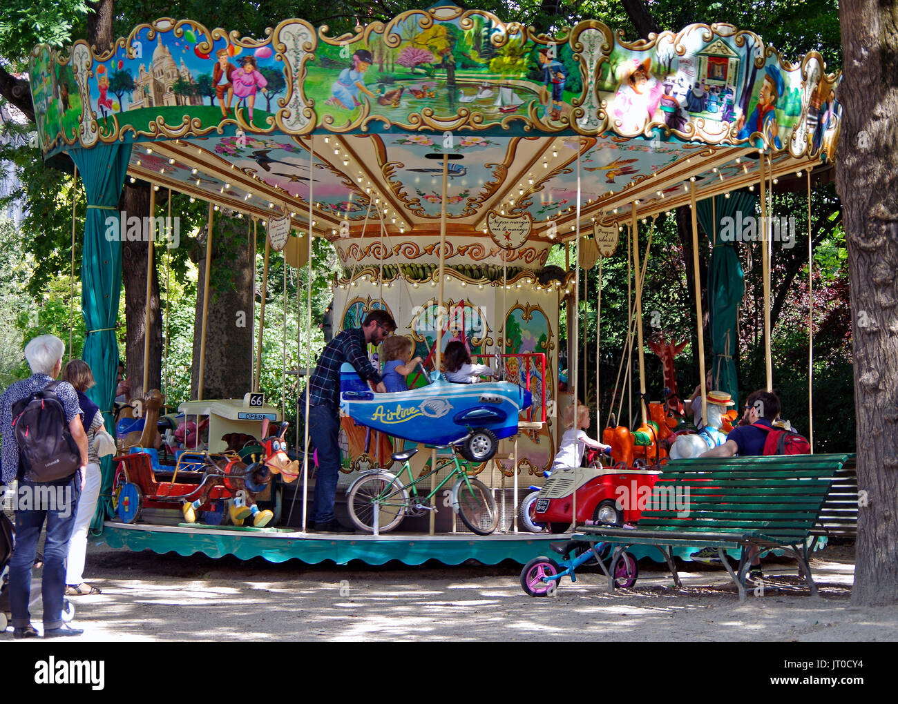 Children riding on a small carousel, Square des Batignolles, Paris ...
