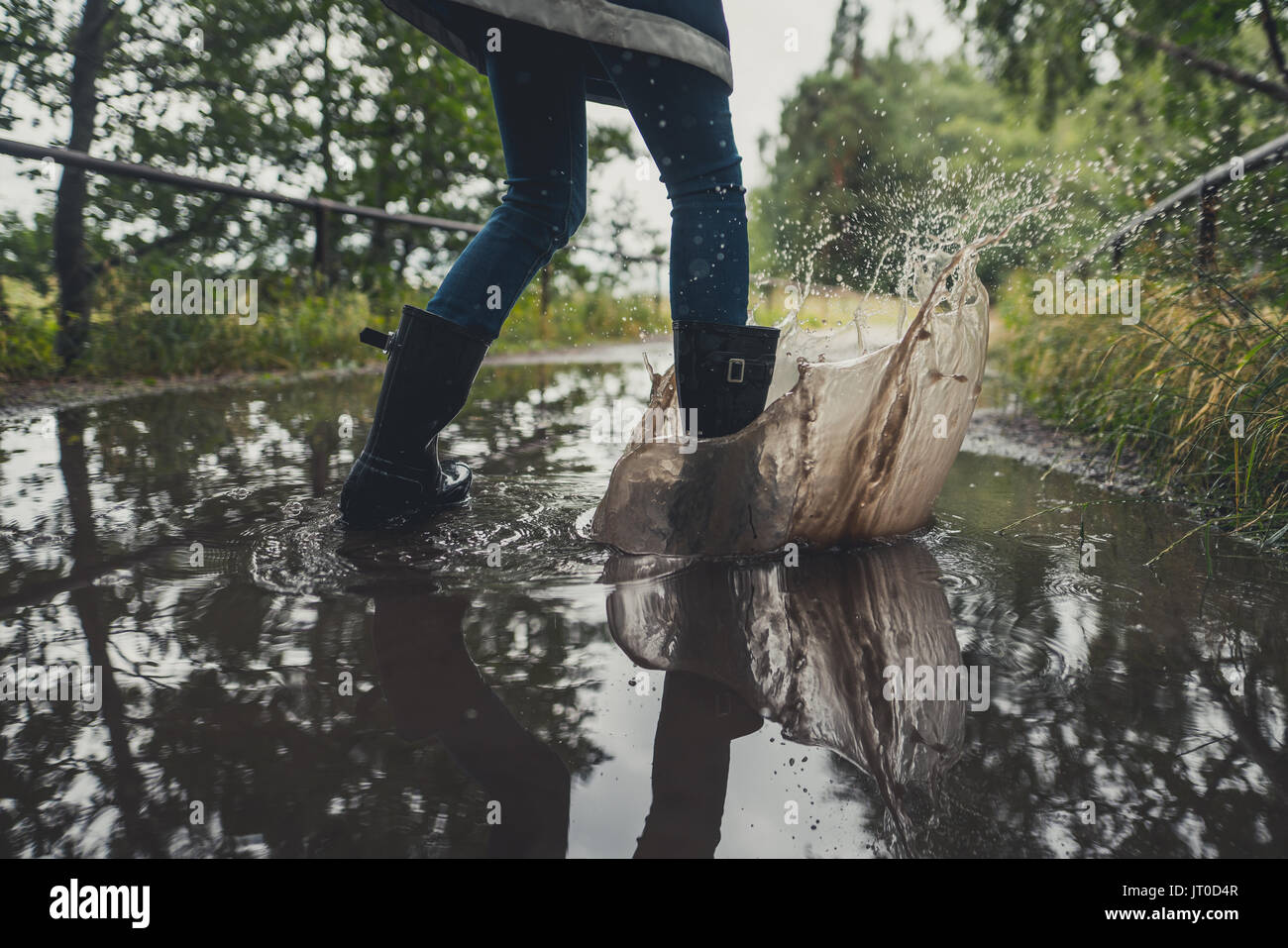 close-up of young woman's legs with rubber boots jumping and dancing in ...
