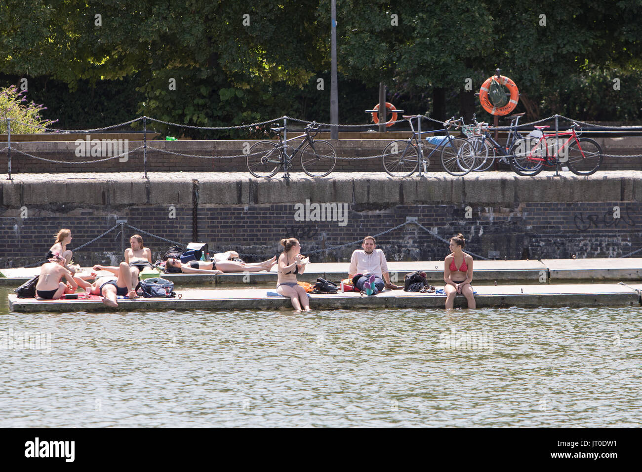 Office worshippers relax at Wapping docks in the sunshine. Featuring ...