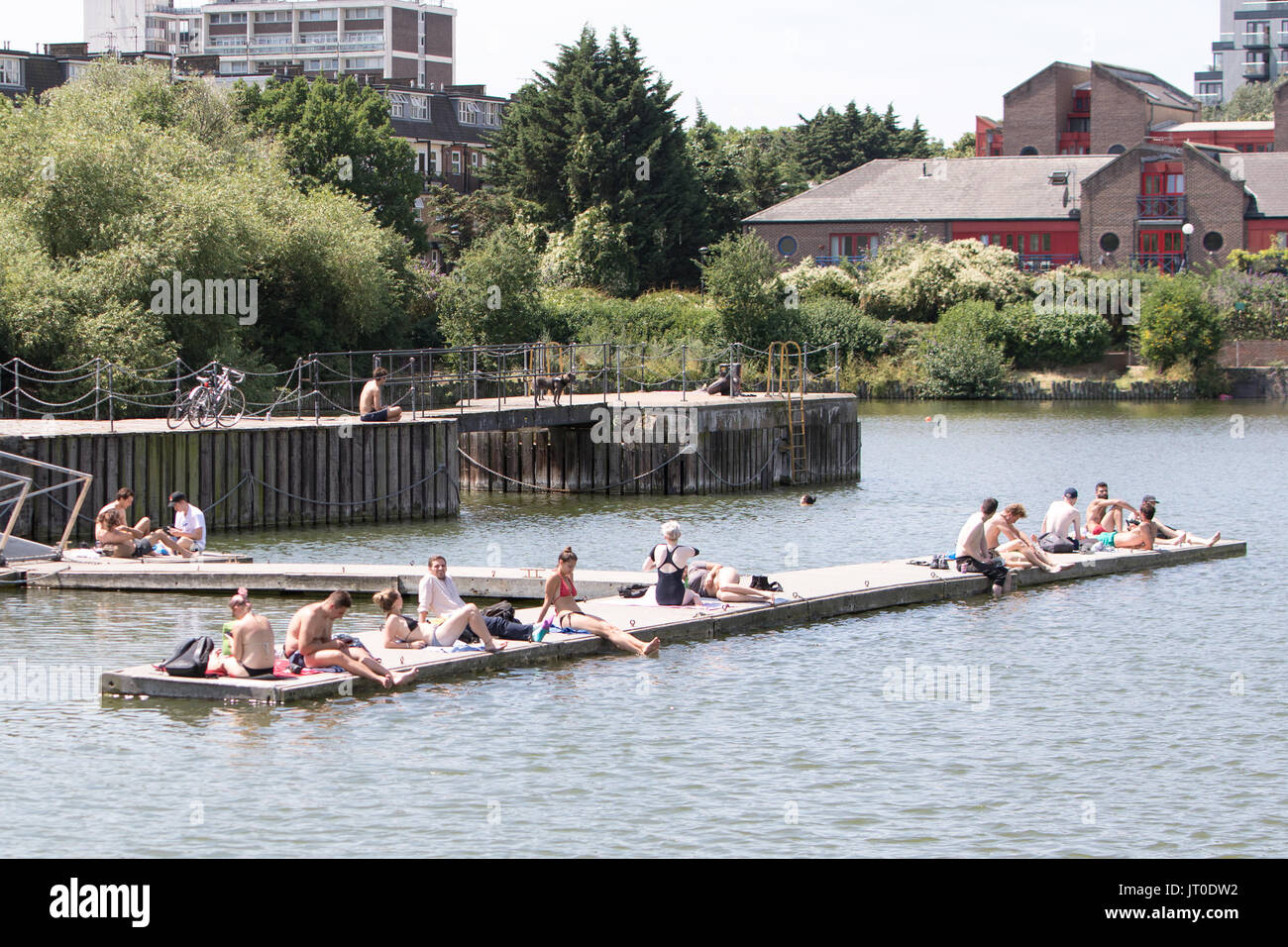 Office worshippers relax at Wapping docks in the sunshine. Featuring ...