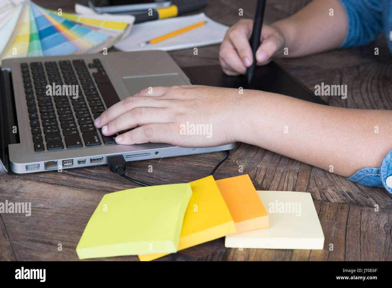 designer drawing on graphic tablet with color sampler palette at office ...