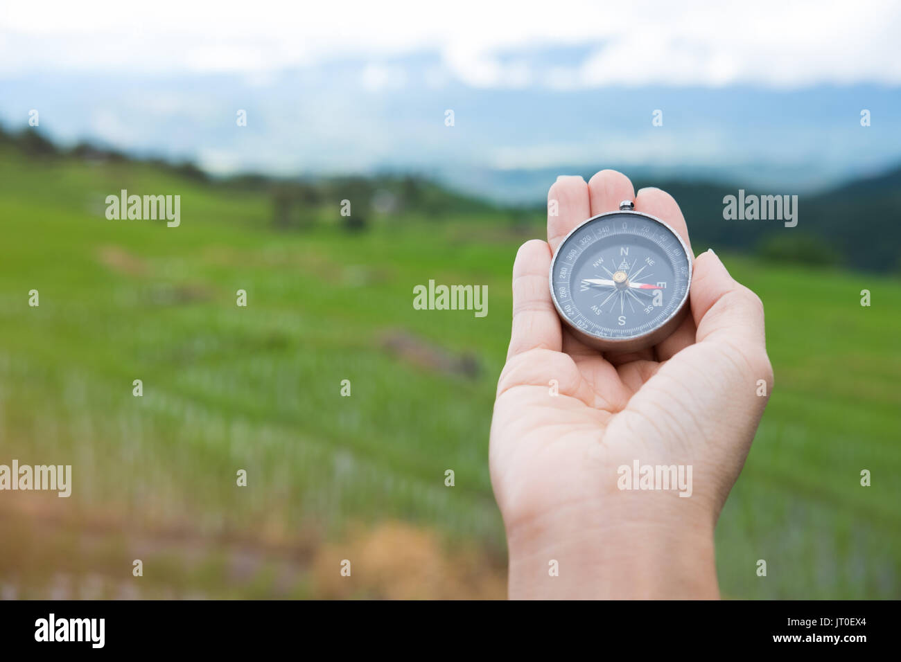 compass in the hand with rice field on terrace nature background ...