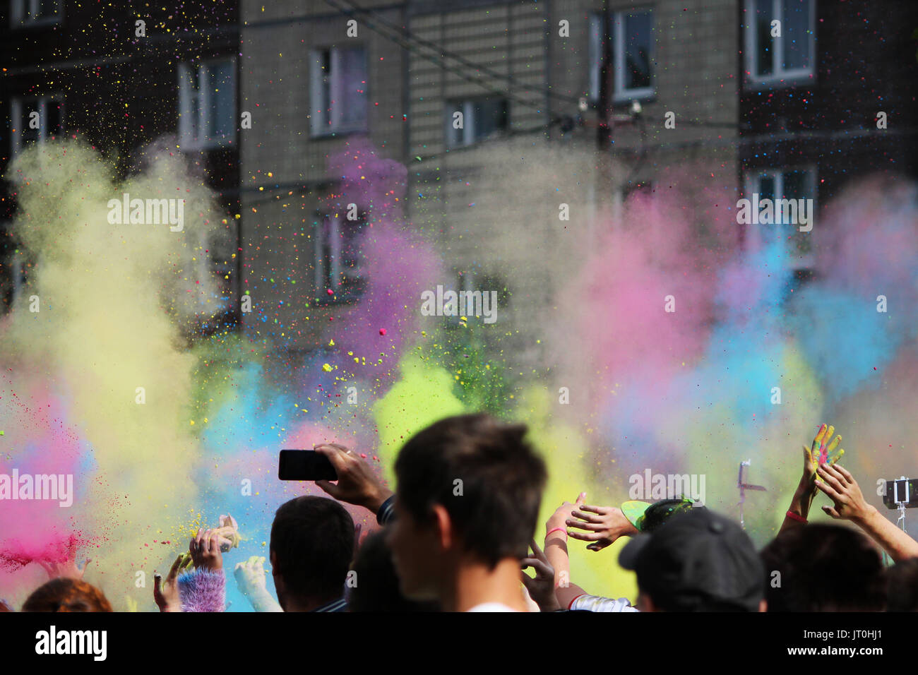 People throw dry colored paint in the air at the festival Holi festival ...