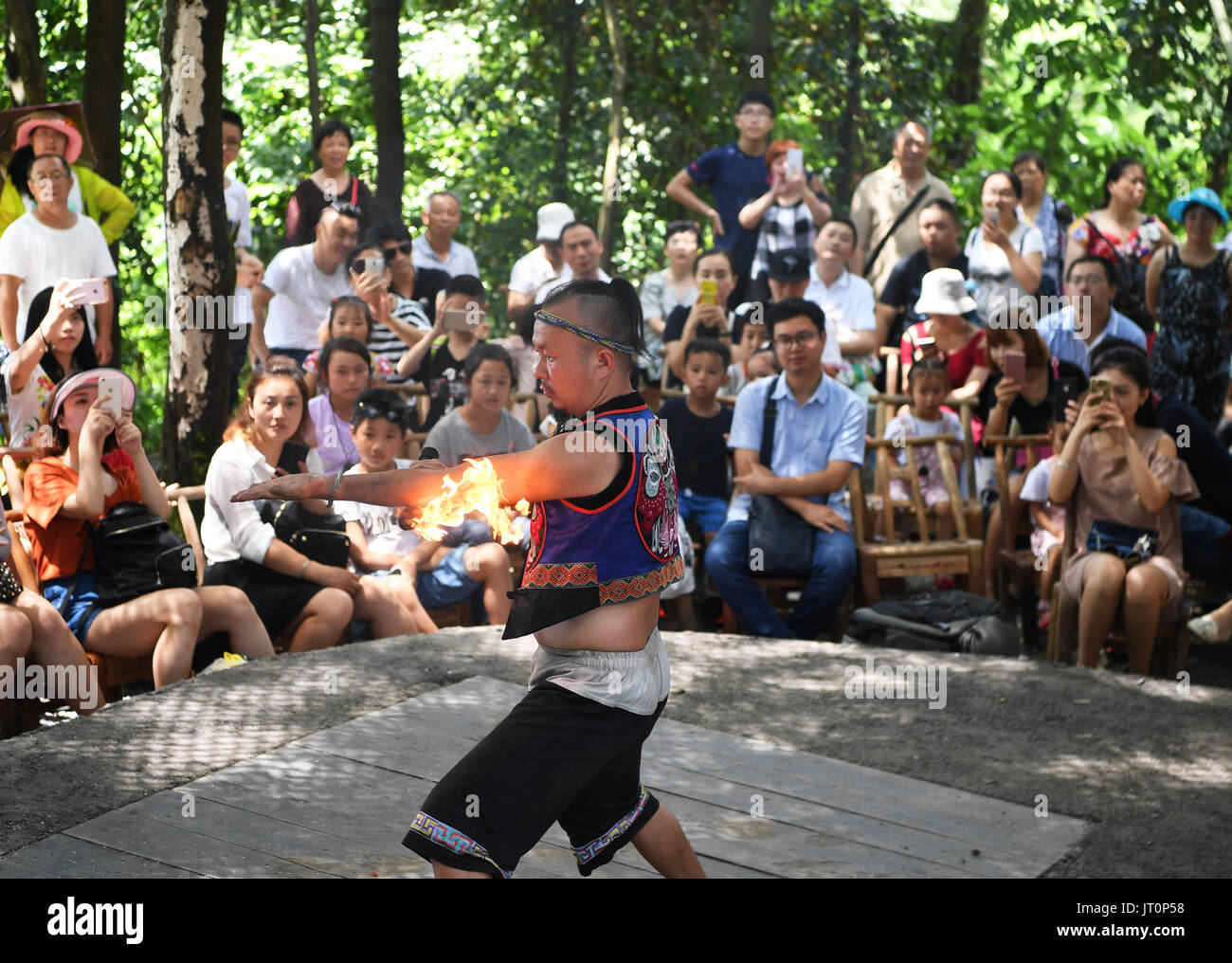 Wulong, China. 6th Aug, 2017. Tourists view a folk performance at ...