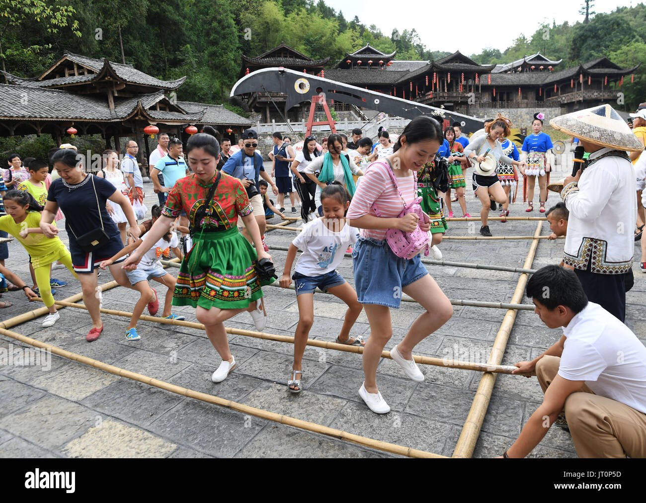 Wulong, China. 6th Aug, 2017. Tourists play the "bamboo dance" at ...