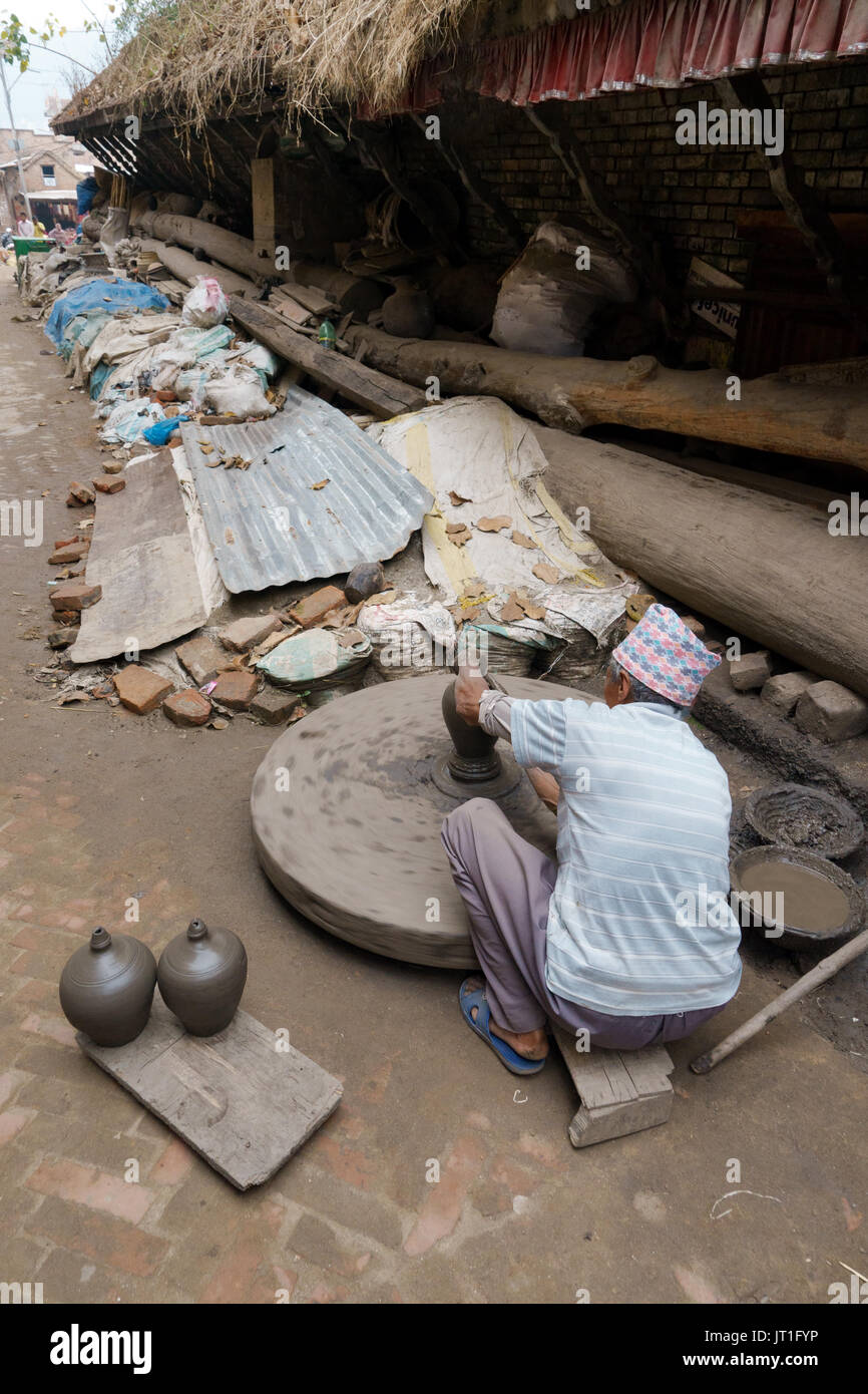 Potter operating a manual stone wheel in Pottery Square, Bhaktapur ...