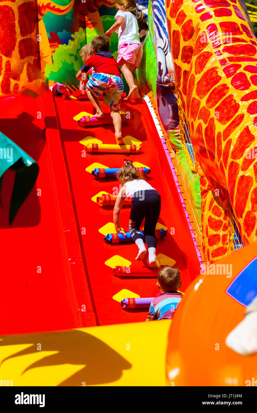 Children play on the inflatable children's playground in the city park ...