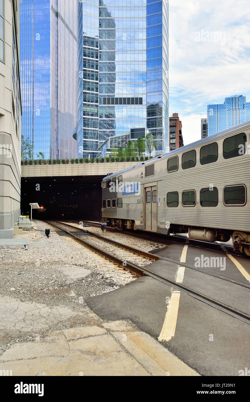 An inbound Metra commuter train entering a tunnel under skyscrapers as it approaches Union ...