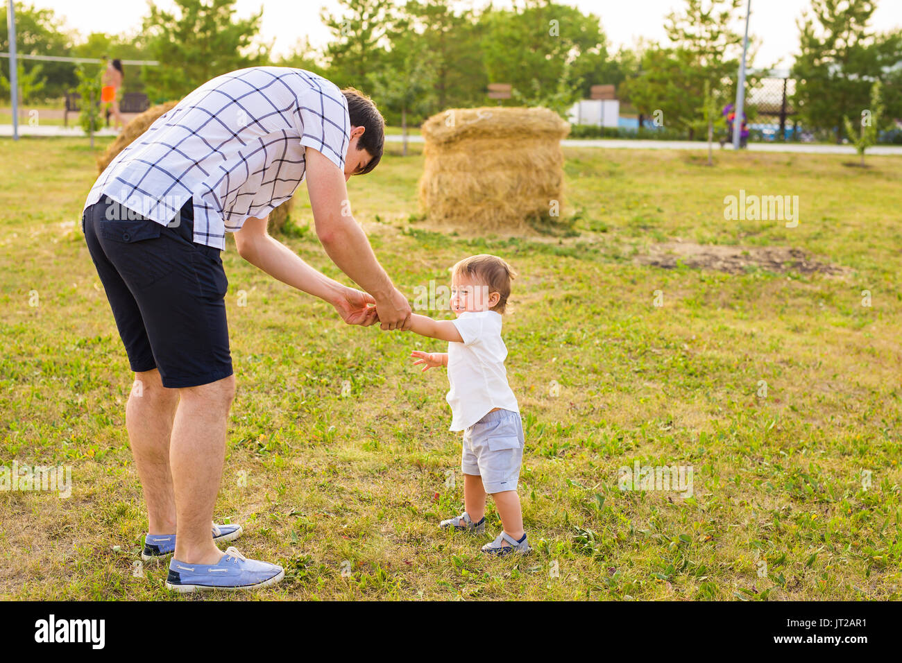 Father and son playing on the field at the day time. People having fun ...