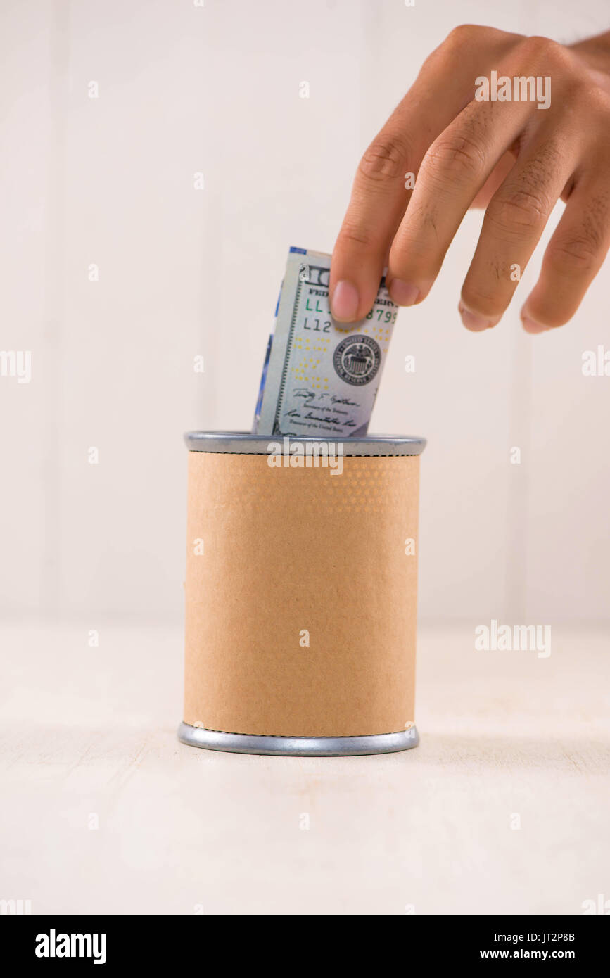 Putting money into donation box. Donate concept Stock Photo - Alamy