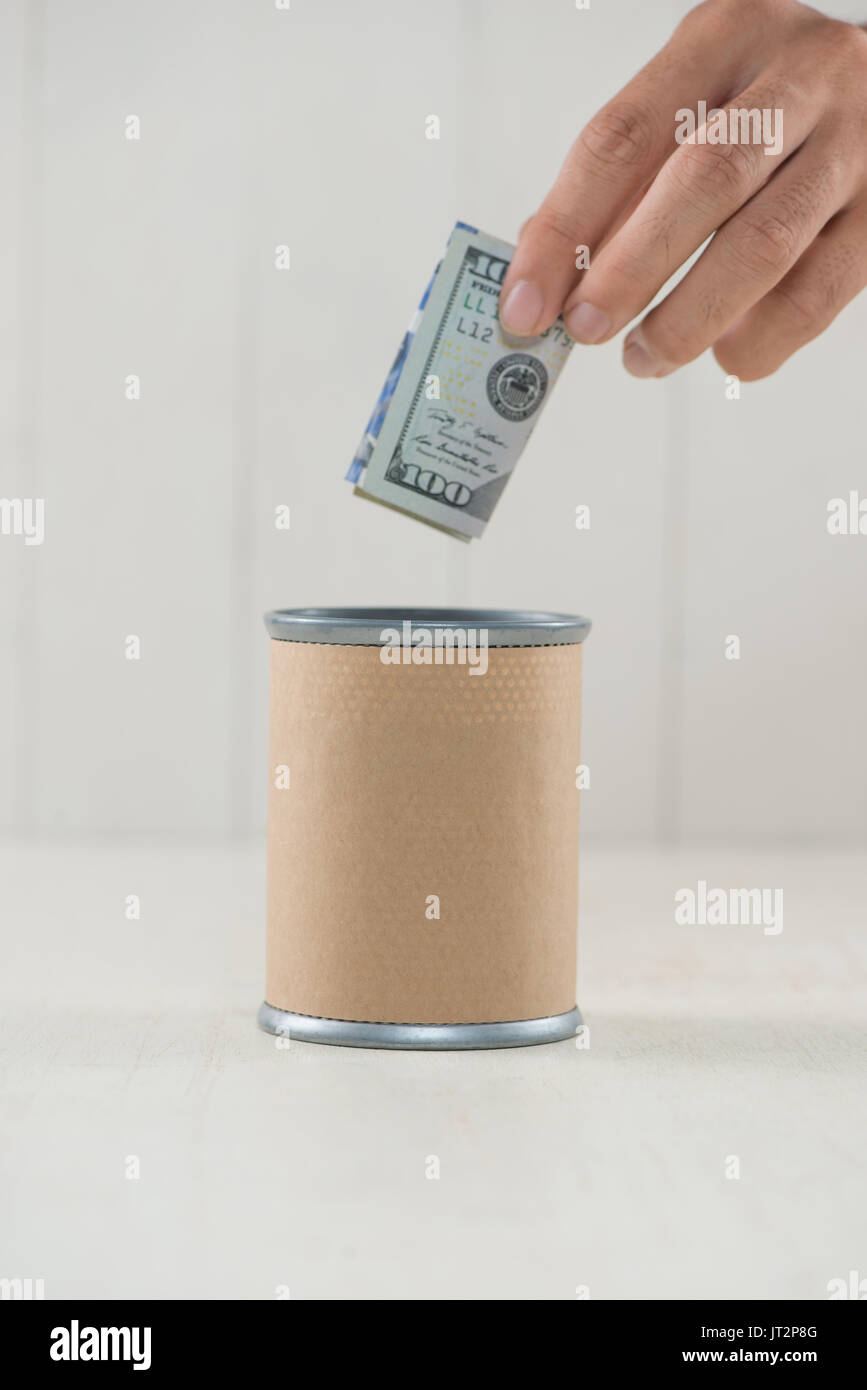 Putting money into donation box. Donate concept Stock Photo - Alamy