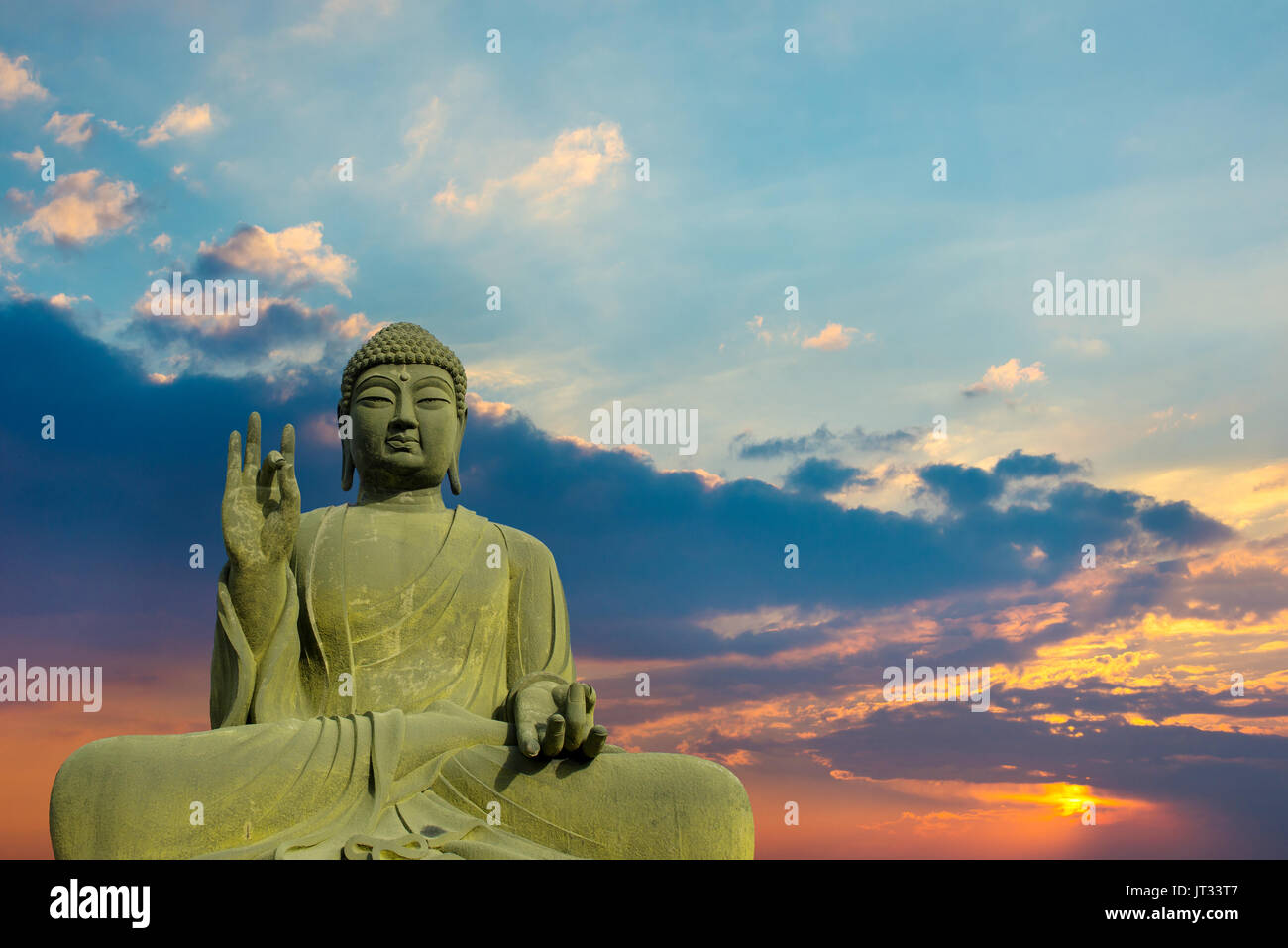 Statue of Buddha at peace with sunset background Stock Photo - Alamy