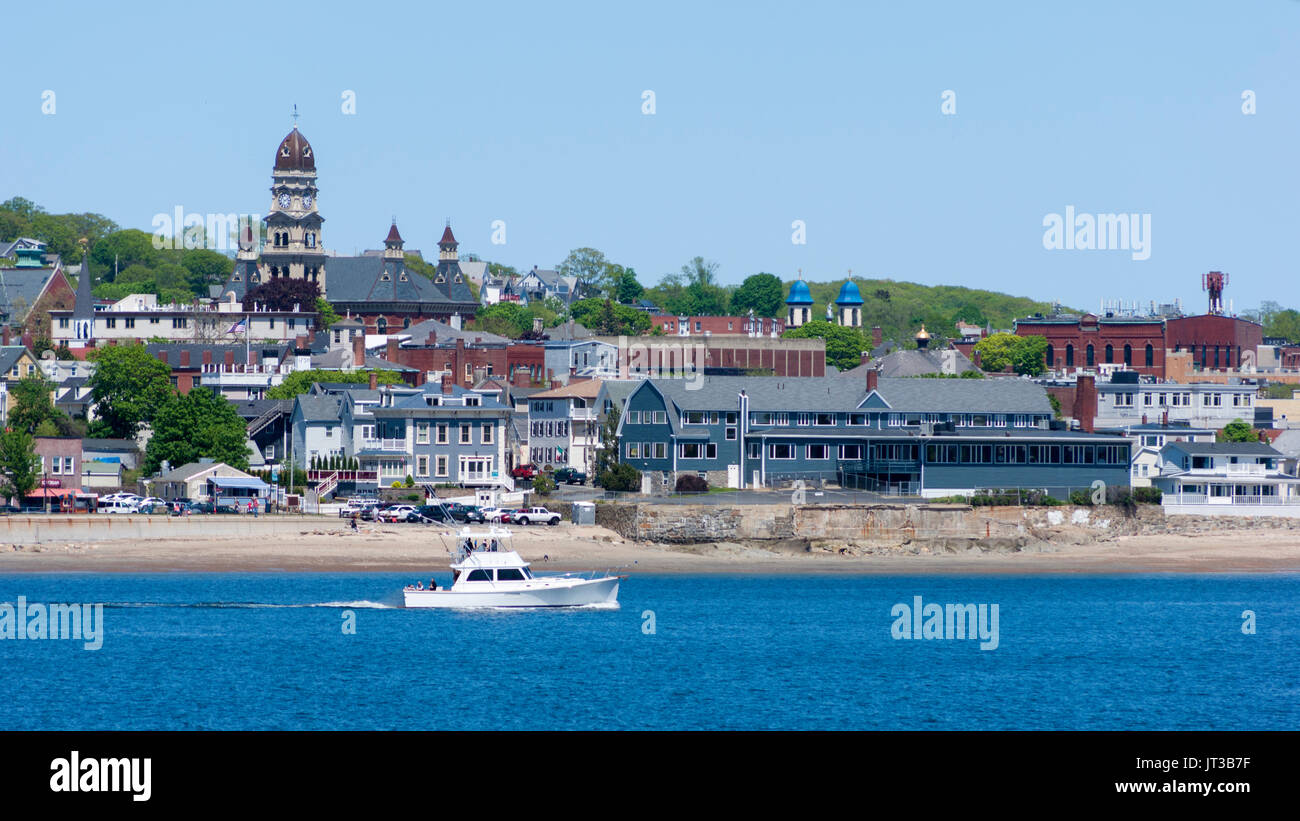 Small yacht cruising in Gloucester Harbor, with the Gloucester ...