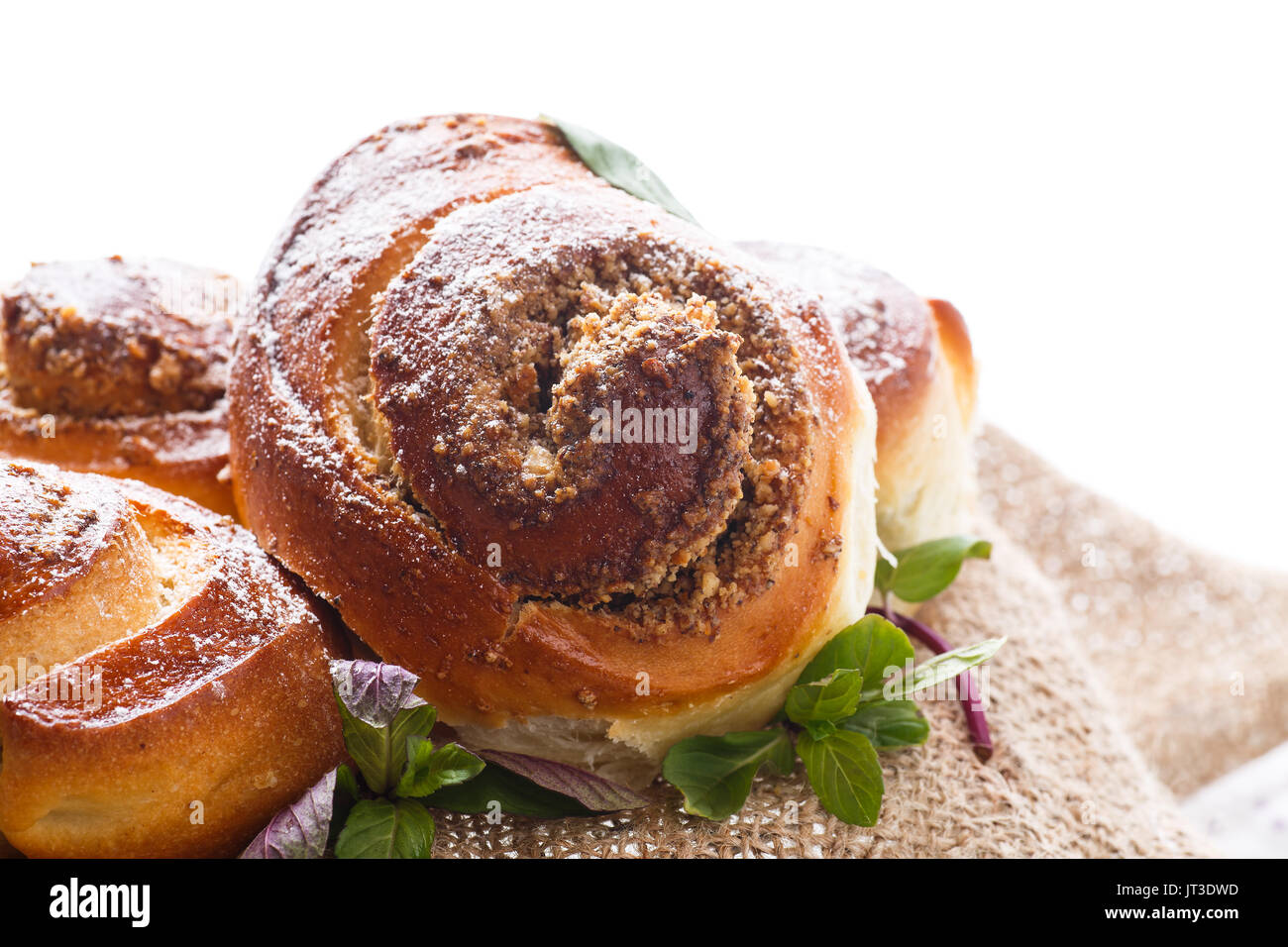 Sweet bun with nut filling in powdered sugar on a white background ...