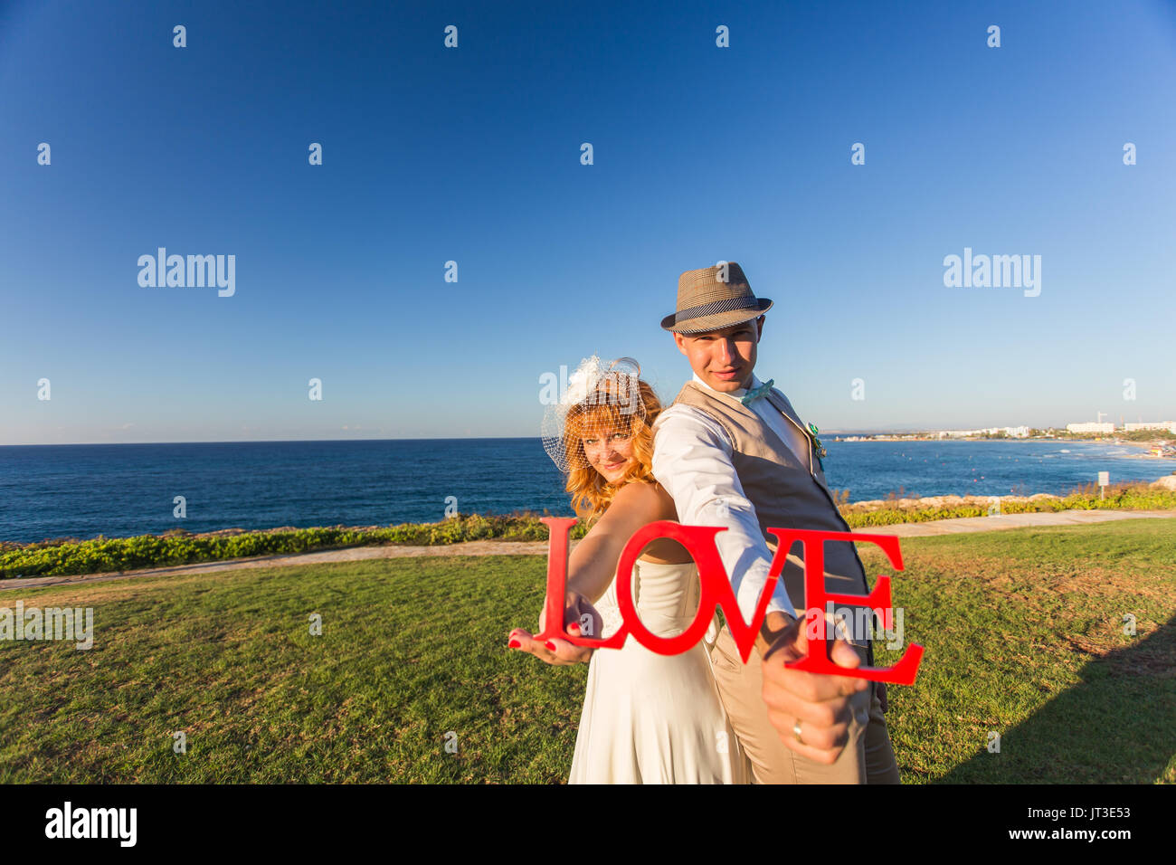 bride and groom with wooden word LOVE Stock Photo - Alamy