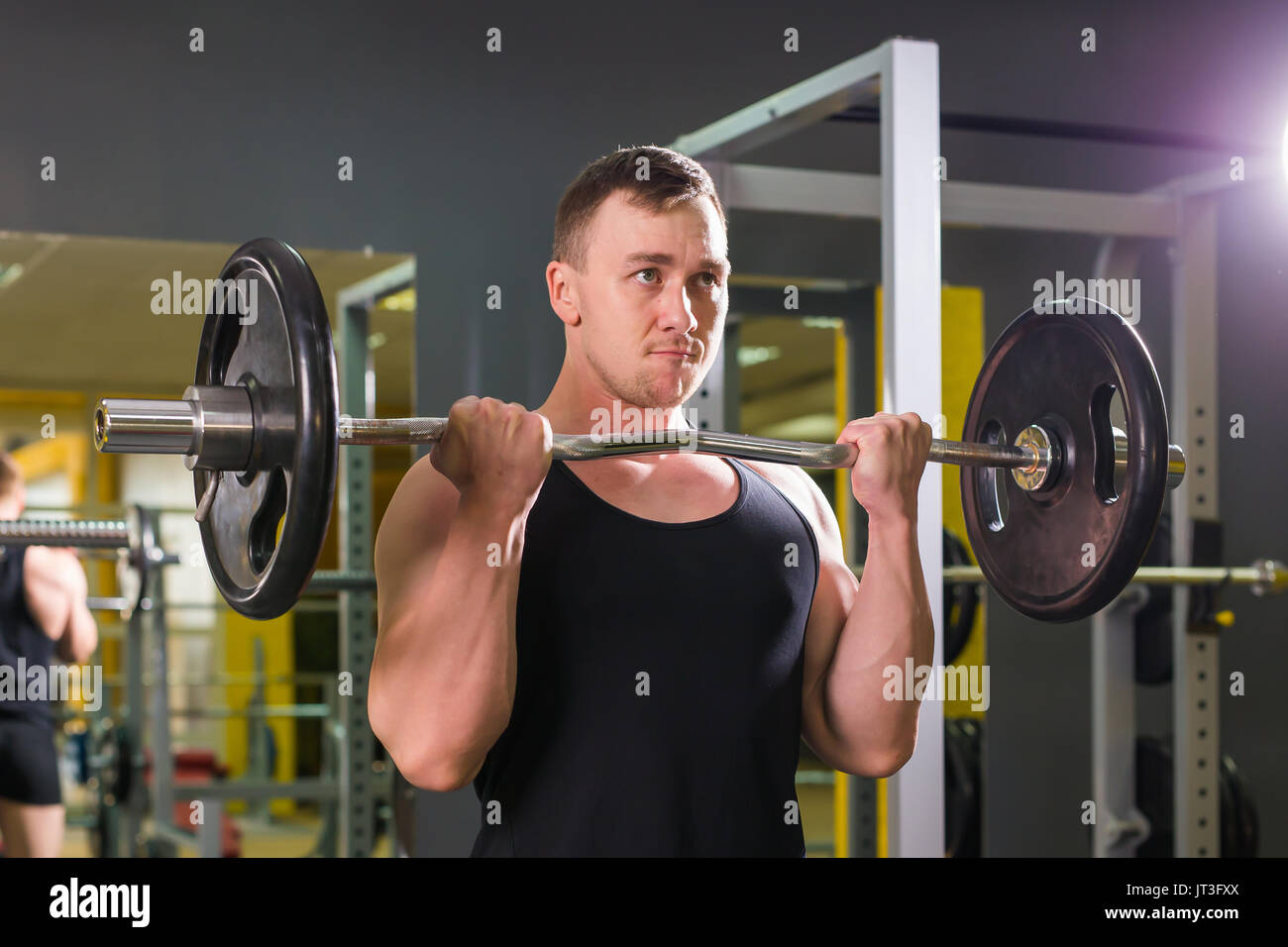 Strong man - bodybuilder with dumbbells in a gym, exercising with a ...