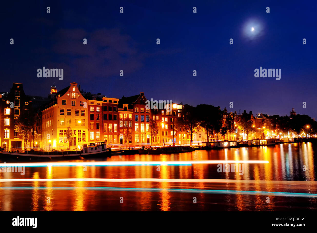 Scenic view of Amsterdam canal, buildings and lights at night ...