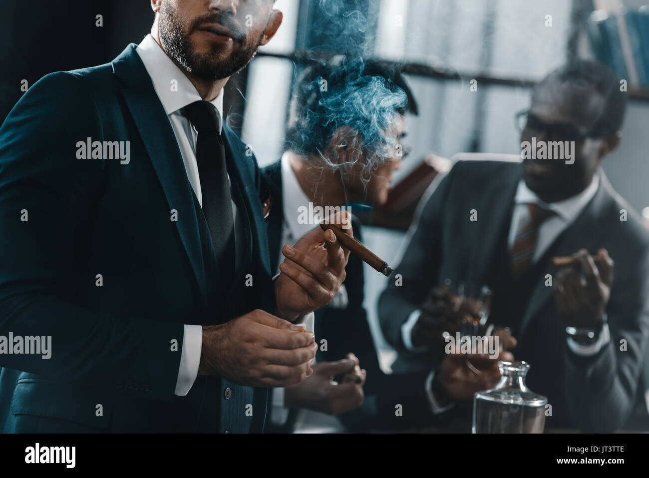 businessman smoking cigar with multicultural business team spending ...