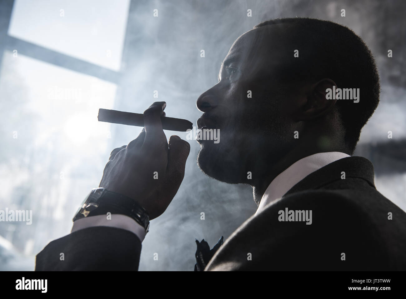 Side view of confident african american man smoking cigar indoors Stock ...