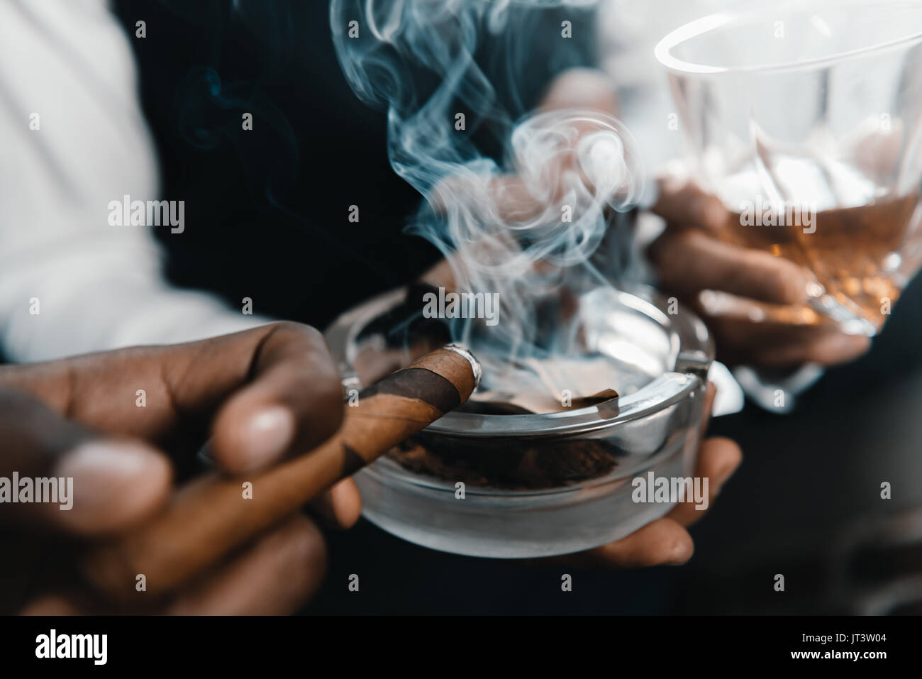 multicultural business team spending time, smoking cigar and drinking ...