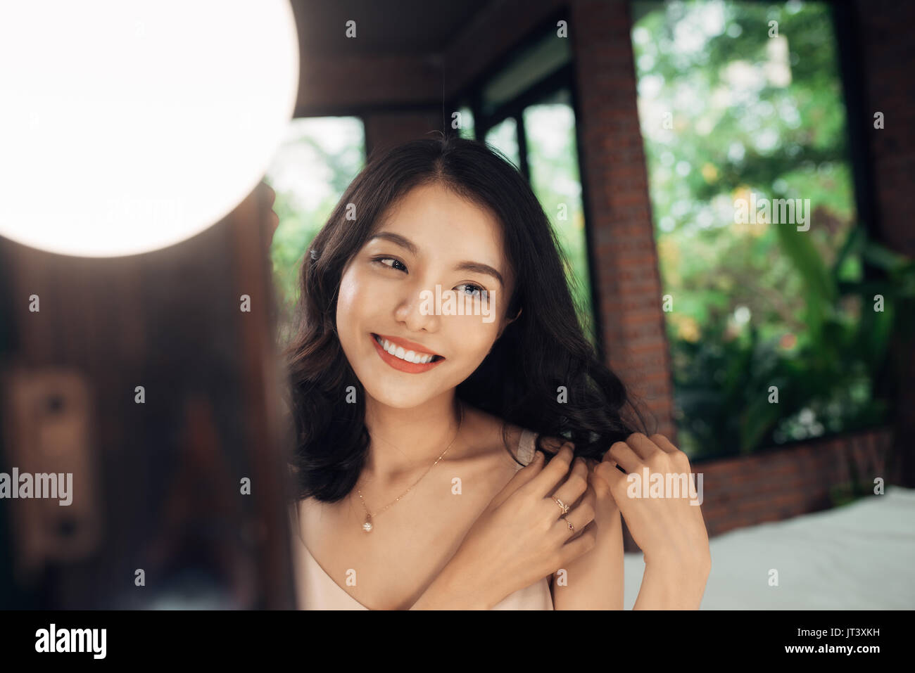 Young woman looking herself reflection in mirror at home Stock Photo ...