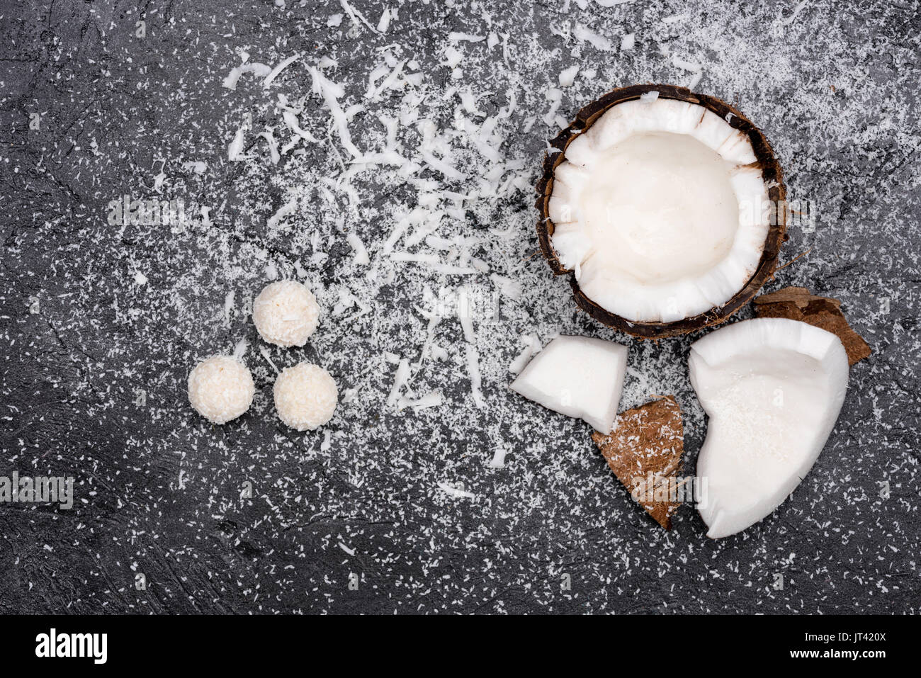 Top view of fresh broken coconut with shavings on black Stock Photo - Alamy