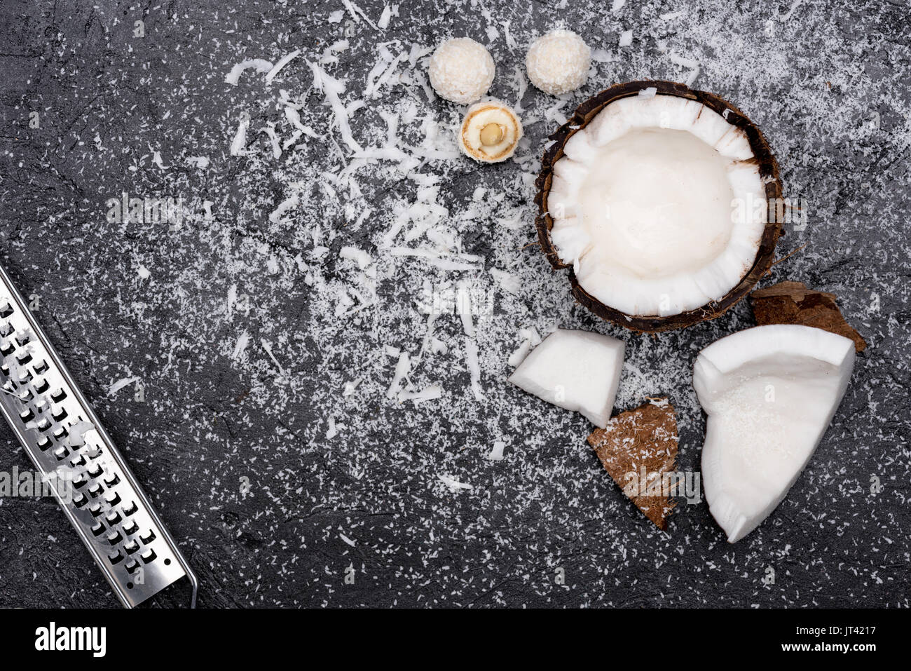 Top view of fresh broken coconut with shavings on black Stock Photo - Alamy