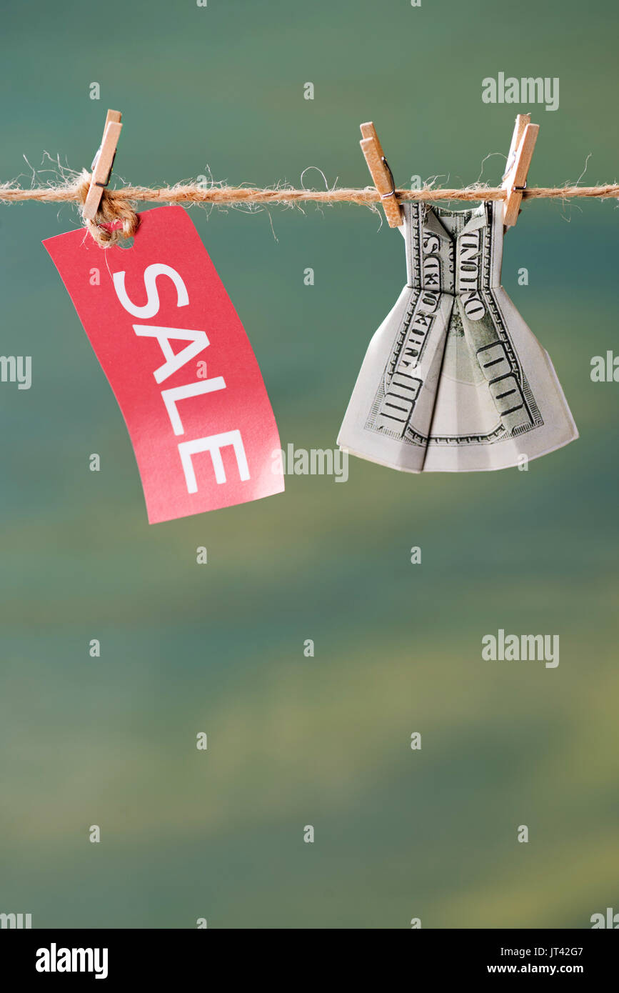 sale sign and one hundred us dollar banknote on clothesline, offer sale ...