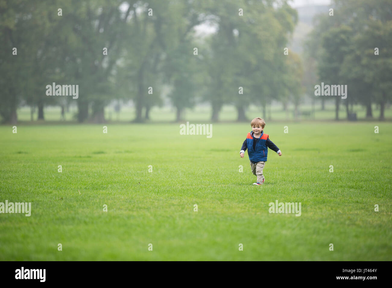 Portrait of a happy young boy running and playing outdoors Stock Photo ...