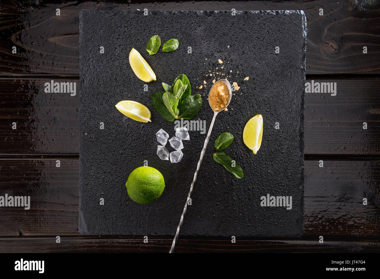 lime slices with mint leaves and mix spoon on stone board, barman ...