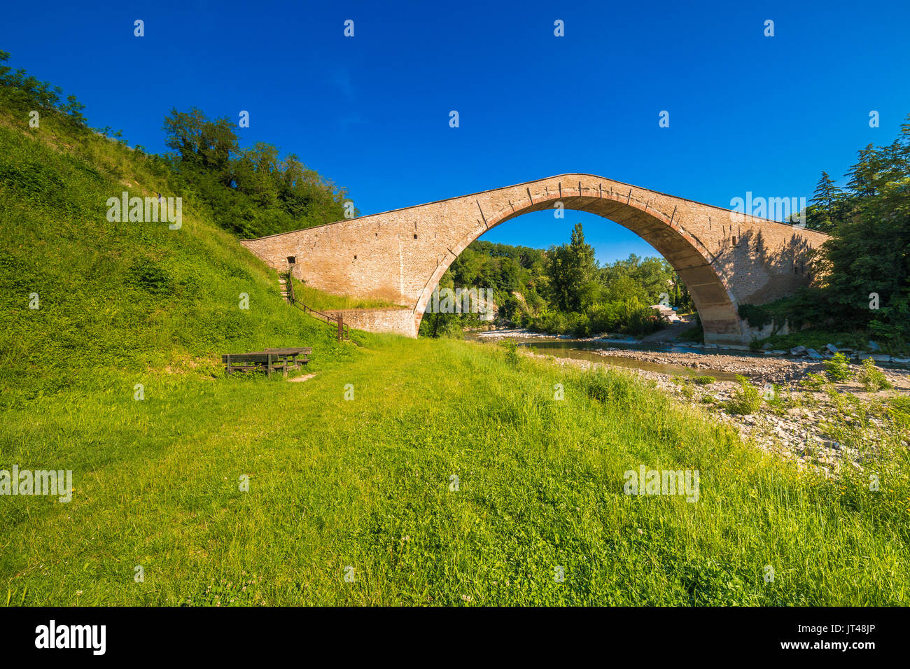 green grass to ancient XVI bridge with donkey back structure, one of ...
