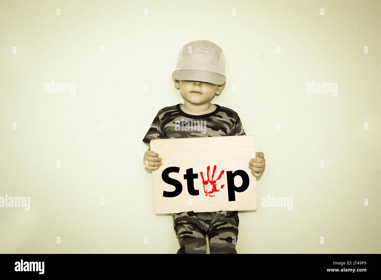 Stop concept of violence. The child is at the wall with a stop sign ...