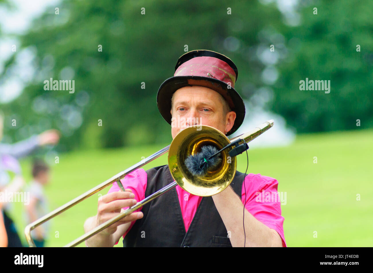 Male musician wearing a top hat plays the trombone and celebrates Sma ...