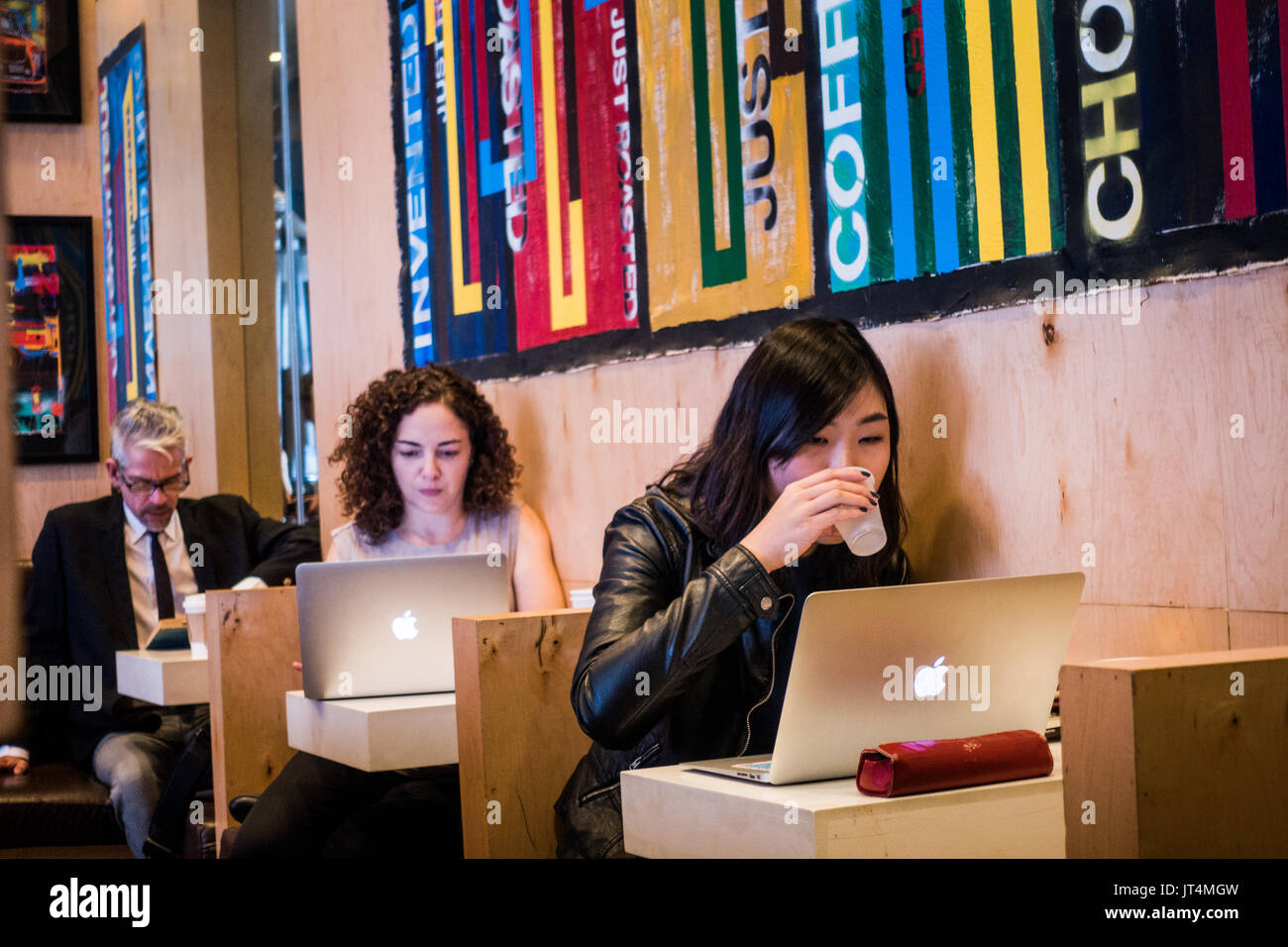 NEW YORK, USA - October 13, 2016. People working on computers in a Cafe ...