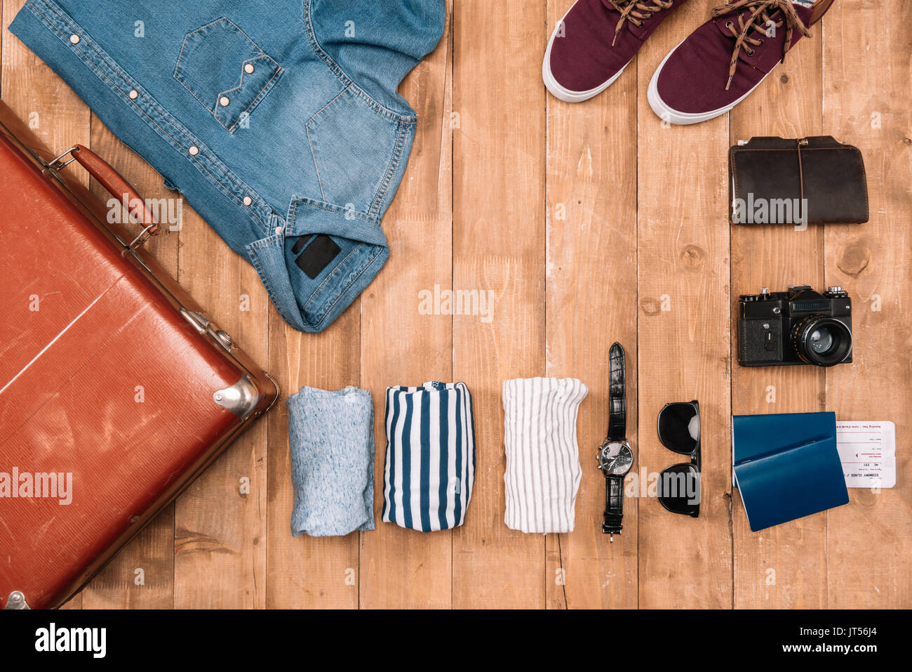 Business travel concept. Flat lay with suitcase, clothes, camera ...