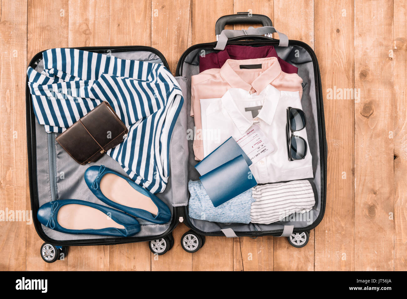 Overhead view of traveler's accessories and clothes organized in open ...