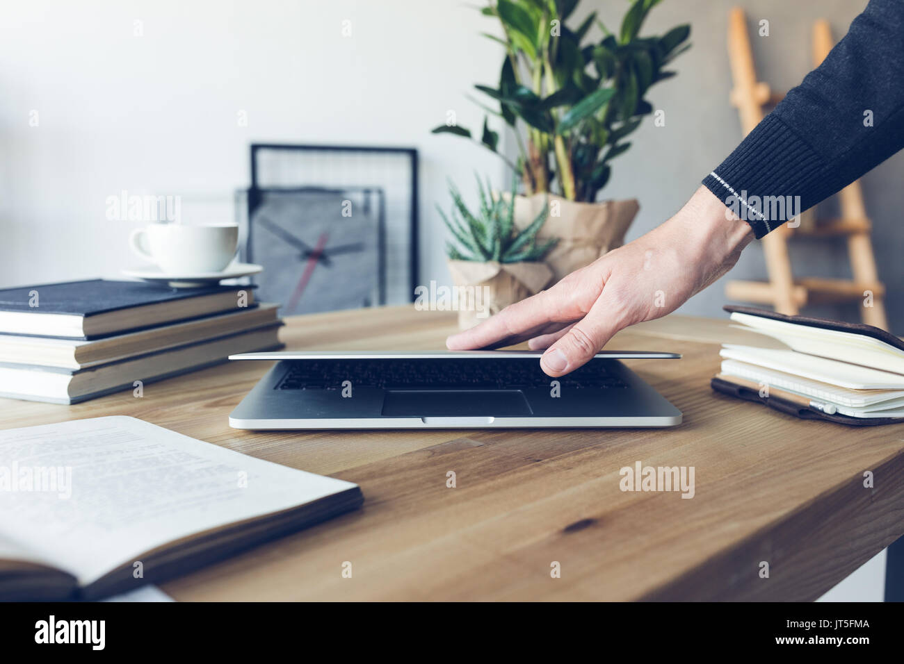 human hand holding laptop at workplace in home office Stock Photo - Alamy