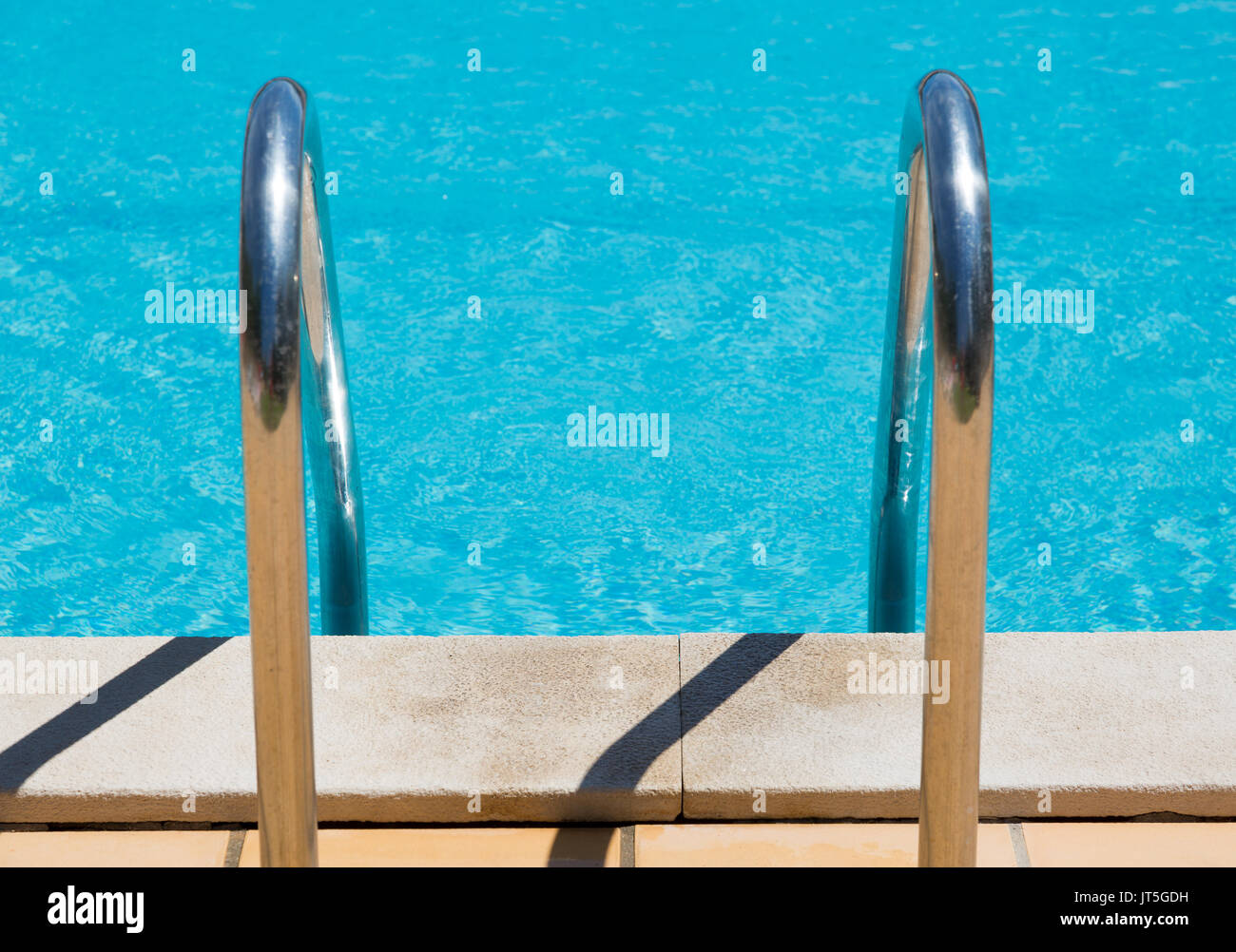 Stainless steel steps leading into swimming pool Stock Photo - Alamy