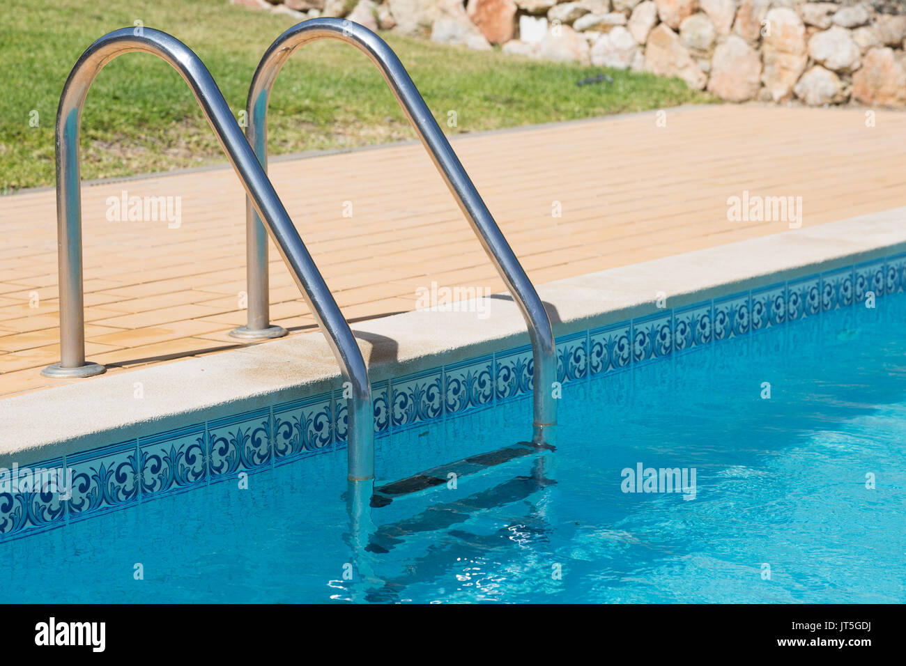 Stainless steel steps leading into swimming pool Stock Photo - Alamy