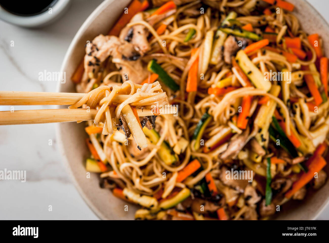 Traditional Asian food. Lunch stirfry: rice noodles, zucchini, carrots ...