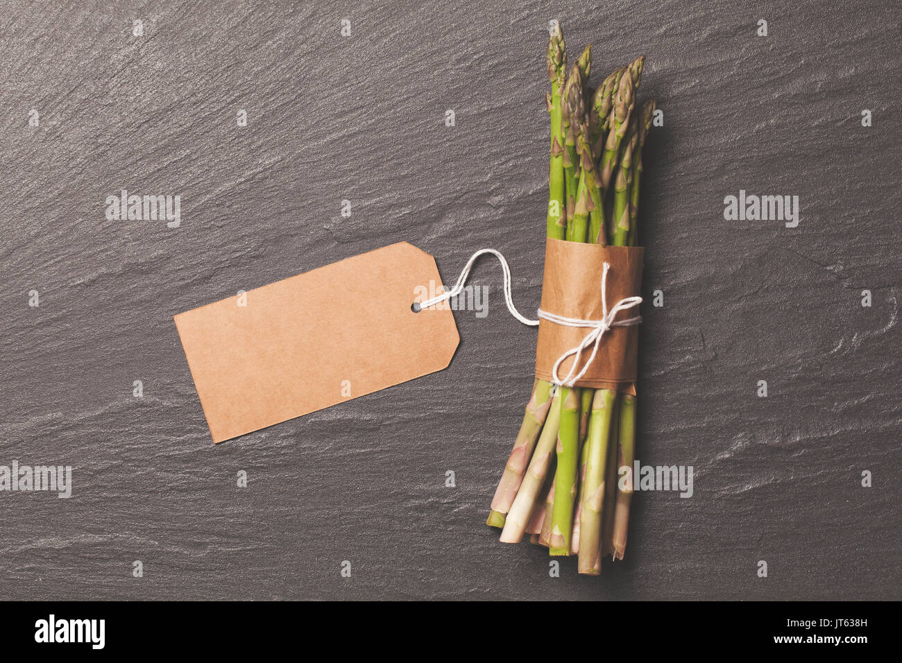 Fresh asparagus tied in a bunch on a rustic slate background with blank ...