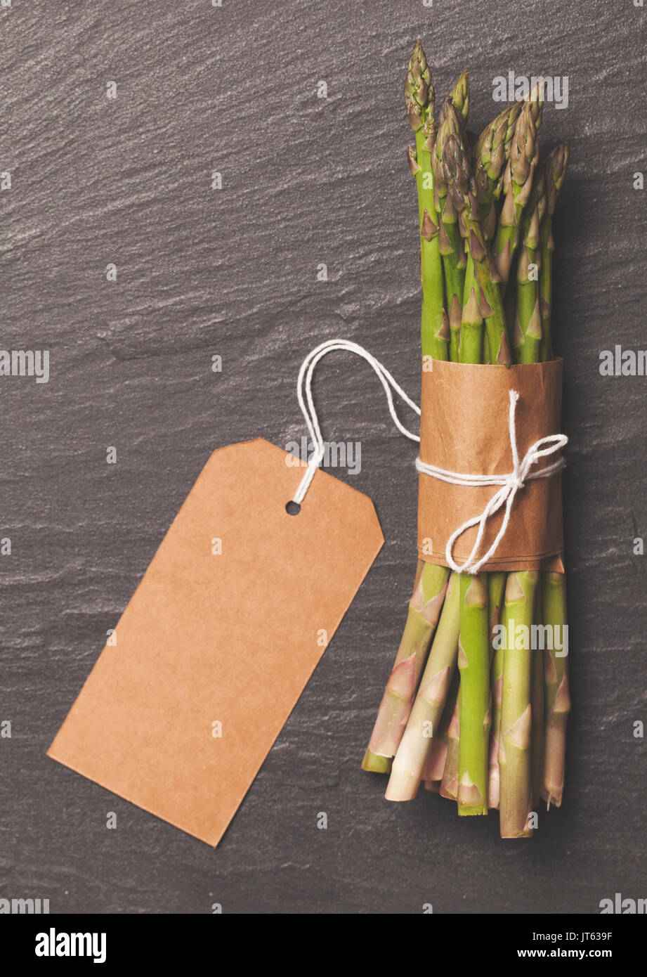 Fresh asparagus tied in a bunch on a rustic slate background with blank ...