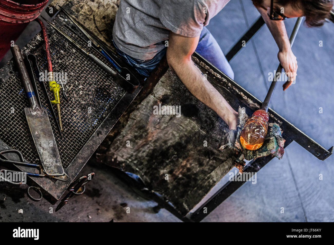 Man Hands Closeup Shaping a Blown Glass Piece with a Wet Newspaper ...