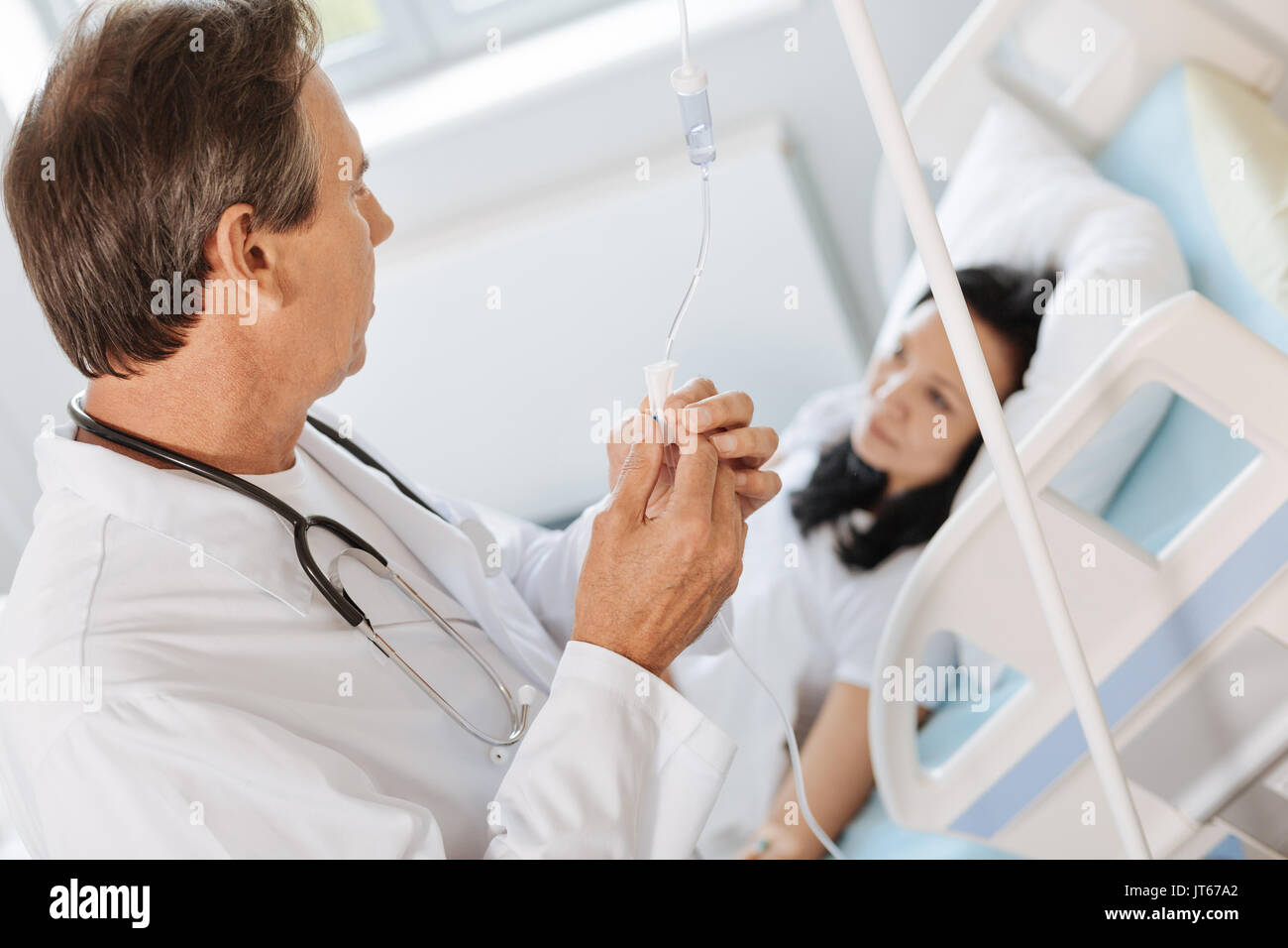 Professional experienced doctor treating his patient Stock Photo - Alamy