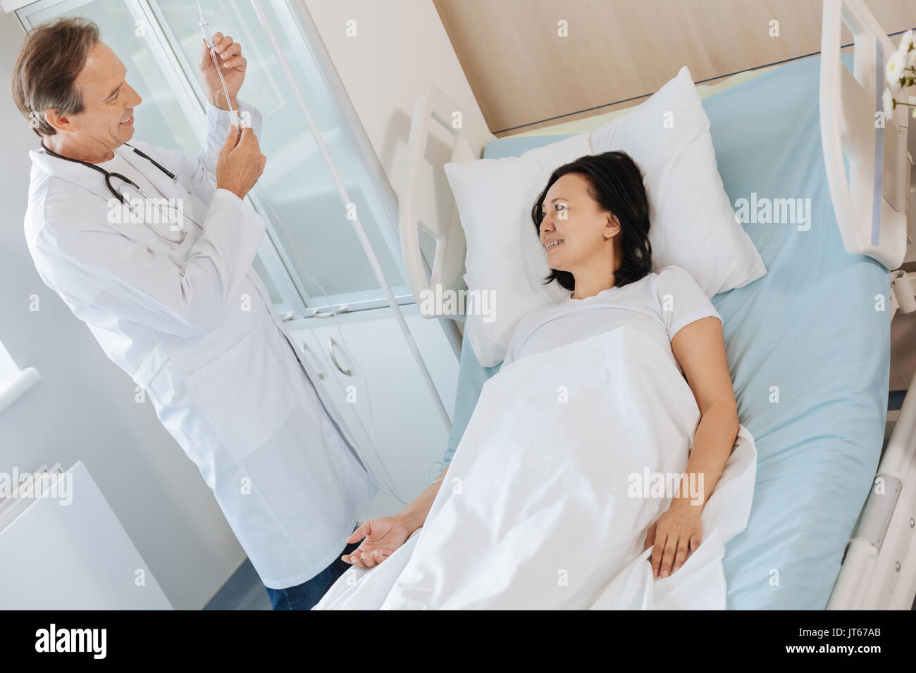 Joyful friendly doctor speaking with his patient Stock Photo - Alamy
