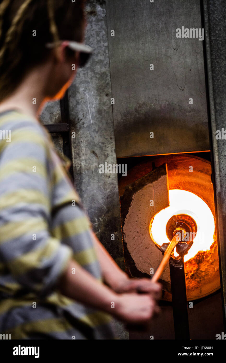 Glassmaker Flashing and Warming Piece of Glass in the Kiln with Blowing ...